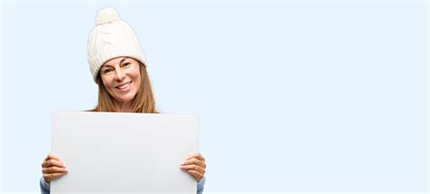 모직 겨울 모자 빈 광고 배너 광고 제공 또는 발표 큰 종이 판에 대 한 좋은 포스터를 들고을 착용 해 중간 나이 여자 간판에 대한 스톡 사진 및 기타 이미지 Istock