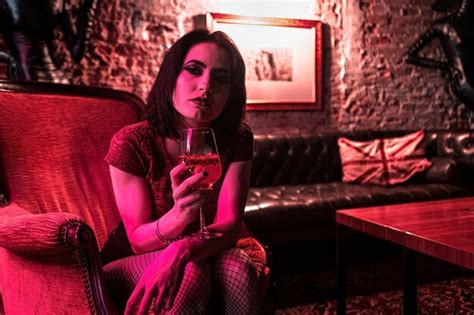 Premium Photo Seductive Rebel Brunette Girl Holding Drink On Vintage Chair With Provocative Gaze
