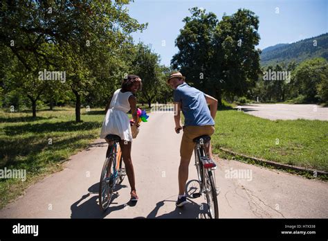 A Young Man And A Beautiful Black Girl Enjoying A Bike Ride In Nature