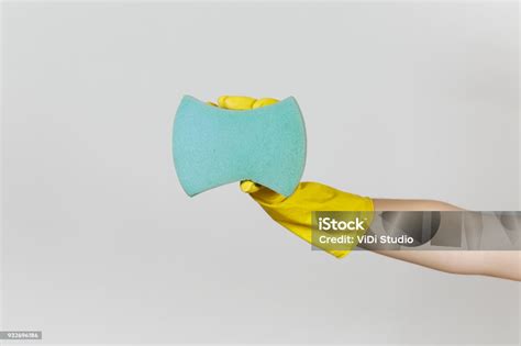청소에 대 한 노란색 장갑 블루 수평 보유 대형 스폰지에 여성 손의 닫고 흰색 배경에 고립 설거지 청소 공급 개념입니다 광고에