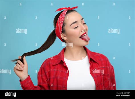 Happy Woman Showing Her Tongue On Light Blue Background Stock Photo Alamy