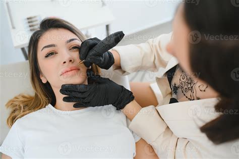 Young Woman Getting Permanent Makeup On Lips In Beautician Salon