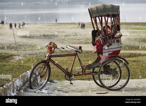 A Rickshaw Puller Sleeping On His Rickshaw In The Banks Of Brahmaputra