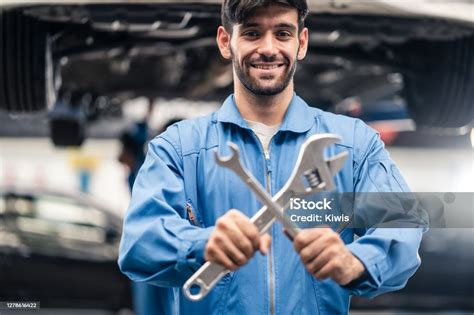 잘 생긴 백인 자동차 정비사 남성 노동자 유지 보수 및 수리 자동차 차고 상점에 서 장비 도구를 들고 남성 노동자 작업장에서