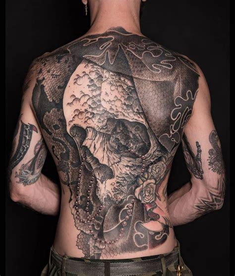 The Back Of A Man With Tattoos On His Body