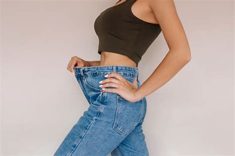 Wanita Muda Bugar Mengenakan Jeans Lebar Dan Atasan Menunjukkan