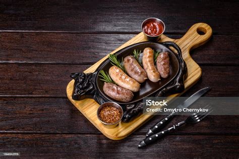 아름다운 주철 팬에 붉은 소스를 곁들인 맛있는 신선한 육즙 이 많은 소시지 그릴 가공육에 대한 스톡 사진 및 기타 이미지