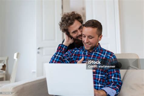 Pasangan Gay Yang Cantik Tertawa Bersama Sambil Duduk Di Ruang Tamu