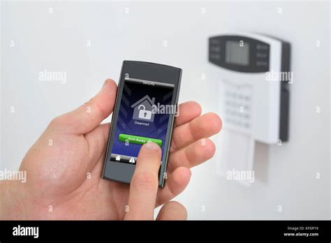 Security Alarm Keypad With Person Arming The System With Remote Controller Stock Photo Alamy