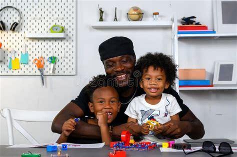 Loving Father Teaches And Plays With Son At Home For Learning And