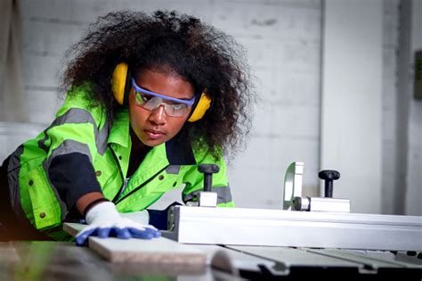 곱슬 머리를 가진 아프리카 산업 여성 노동자는 안전 조끼와 보호 헤드폰을 착용하고 목재 절단기로 작업하며 여성 엔지니어는 Cnc 목공 제조 가구 공장에서 일합니다 20 24