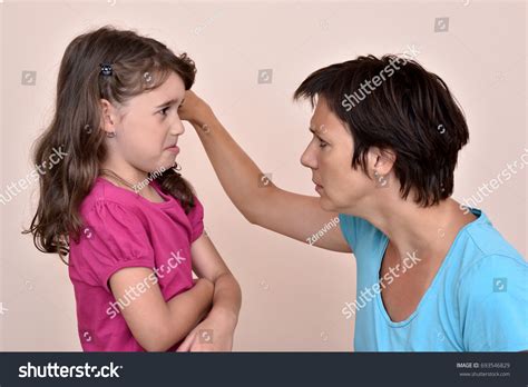 Mother Scolding Pulling Ear Scared Daughter Foto Stok 693546829