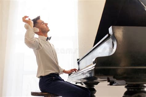Young Guy In White Shirt Plays On Old Black Piano Musician Pianist