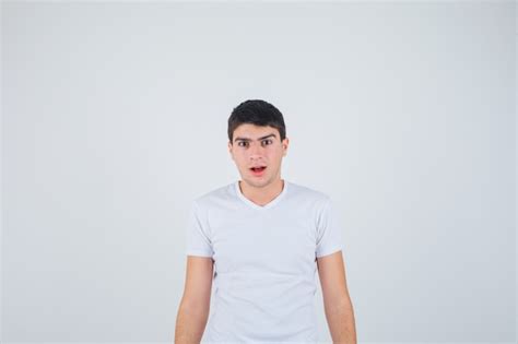 젊은 남성 티셔츠에 카메라를보고 당황한 전면보기를 찾고 무료 사진