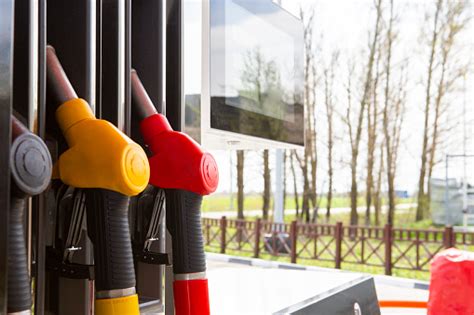 가솔린과 디젤 연료에 근접 연료 노즐 주유소 펌프 남자는 노즐을 들고 자동차 연료로 가솔린을 급 유 필드의 제한 된 깊이입니다 0명에 대한 스톡 사진 및 기타 이미지