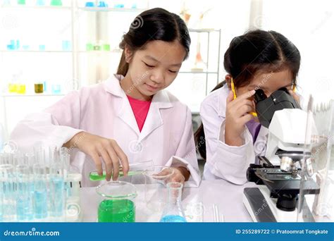 Adorable Colegiala Asiática En Una Bata De Laboratorio Vertiendo