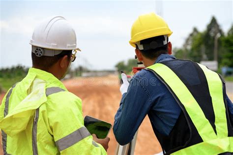 Asian Surveyor Engineer Two People Checking Level Of Soil With Surveyor