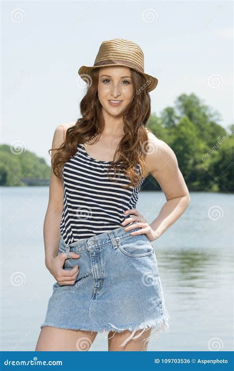 Beautiful Redhead Woman Poses Near Water In Denim Skirt Stock Photo Image Of Cute Ginger