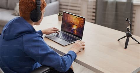 빨간 머리의 십대 소년이 헤드폰과 카메라로 비디오 게임을 하고 있는 뒷모습 초상화 온라인 스트리밍 복사 공간 사진 Unsplash의 랩톱 이미지