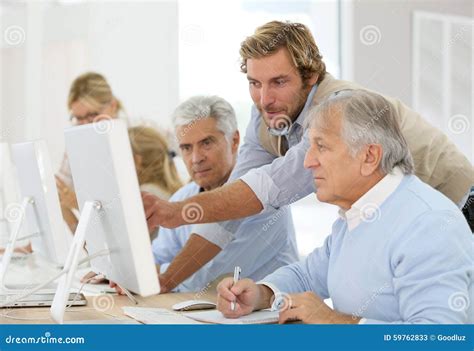 Instructor Helping Seniors In Informatics Class Stock Image Image Of