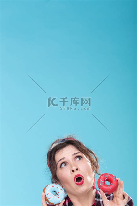 垃圾食品、饮食和不健康的生活方式概念 — 蓝色背景中带甜甜圈的美女高清摄影大图 千库网