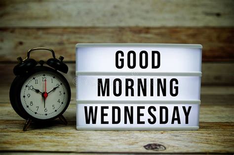 Good Morning Wednesday Text On LED Lightbox With Alarm Clock On Wooden