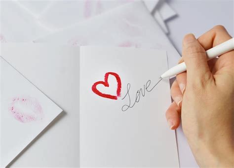 Mano Cortada Sosteniendo Una Pluma Blanca Escribiendo Amor En Una
