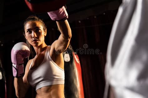 Asian Female Muay Thai Boxer Punching In Fierce Boxing Training