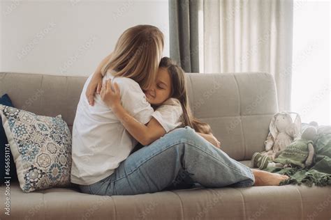 Smiling Mommy Sitting On Sofa With Little Daughter Showing Love