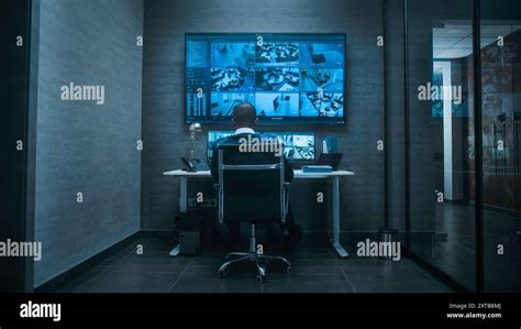 African American Male Cctv Operator Controls Office Surveillance Cameras Using Computer Works