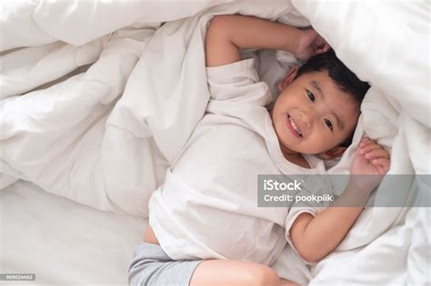 3 년 오래 된 작은 귀여운 아시아 소년 집에서 침대에 아이 화이트 침대 베개와 담요 복사 공간 평면도에 연주와 웃는 거짓말 가족에 대한 스톡 사진 및 기타 이미지 Istock