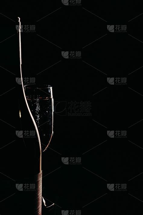 黑色背景上的一瓶葡萄酒和玻璃杯的剪影。静物画，一瓶酒和一个杯子