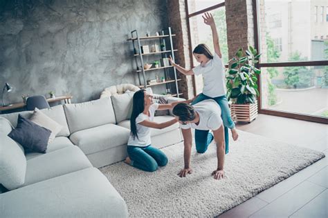 좋은 매력적인 사랑스러운 사랑스러운 쾌활한 쾌활한 가족은 캐주얼 흰색 티셔츠 청바지를 입고 산업 로프트 스타일의 인테리어 거실에서 카펫 바닥에 자유 시간 휴가를 보내고 바보