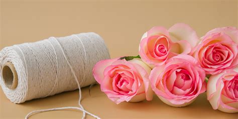 베이지 색 배경에 하트 모양의 흰색 면 로프의 스풀과 섬세한 핑크 장미 최소한의 트렌디 한 구성 로맨틱 한 파스텔 핑크 장미 꽃 중립 지구 색조 발렌타인 데이인사카드 0명에