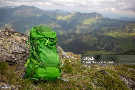 모험 여행 개념 경치 좋은 산 풍경과 구불 구불한 언덕이 내려다 보이는 바위 봉우리에있는 밝은 녹색 배낭 0명에 대한 스톡 사진 및 기타 이미지 Istock