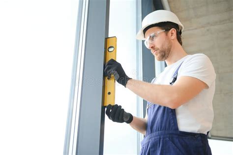 Handsome Young Man Installing Bay Window In New House Construction Site