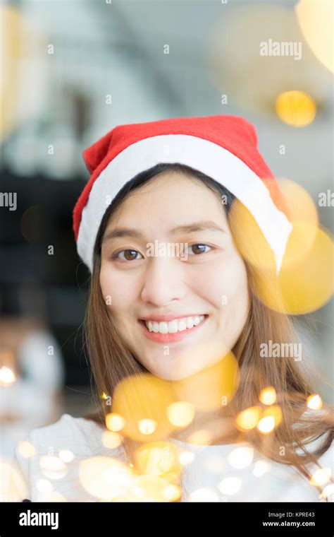 Smiling Asia Woman Wear Santa Hat Holding Party String Lights With