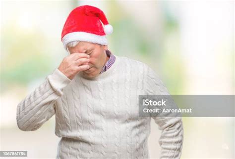 격리 된 배경에 바르고 코와 눈 피로 두통 느낌 피곤 크리스마스 모자를 쓰고 잘생긴 수석 남자 스트레스와 좌절 개념입니다 건강관리와 의술에 대한 스톡 사진 및 기타 이미지