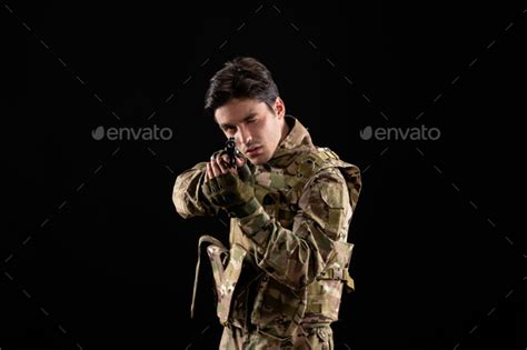 Front View Of Military Serviceman In Uniform With Gun On Black