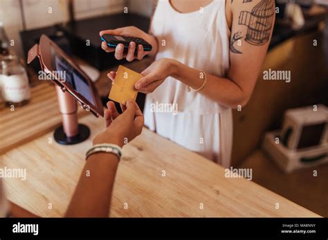 Customer Paying The Bill Using A Credit Card At A Cafe Woman