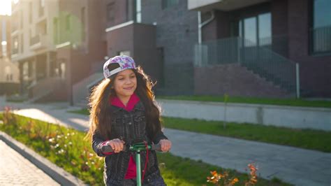 Brunette Girl Riding A Scooter At Sunset In Her Area 23655062 Stock
