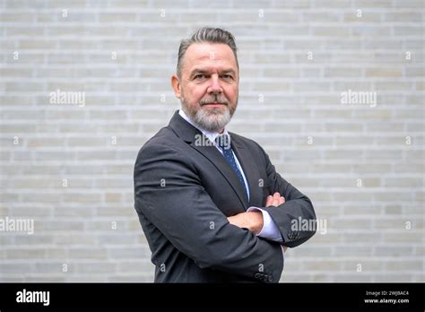 Strict Sixty Year Old Gray Man In Front Of A White Brick Wall With His