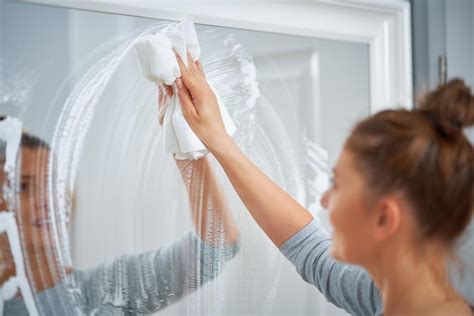 Imagen De Una Mujer Limpiando La Ventana Del Espejo Foto Premium