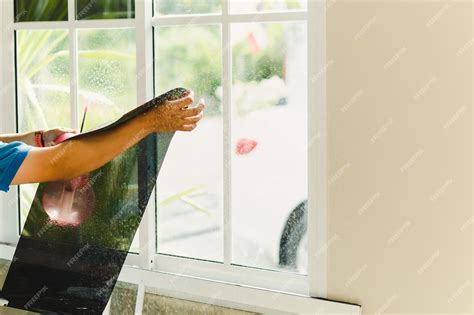 premium photo woker wrapping tinting a house window with tinted foil