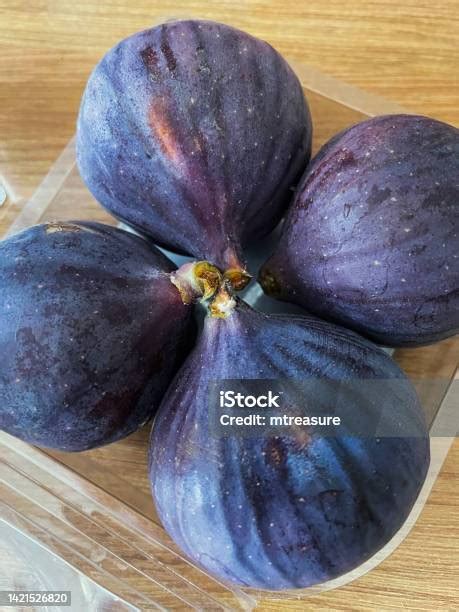 플라스틱 용기에 담긴 네 개의 신선한 익은 무화과의 클로즈업 이미지 우드 그레인 배경 높은 전망 0명에 대한 스톡 사진 및 기타 이미지 Istock