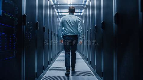 It Engineer Walking Through Data Center With Working Server Rack To Do Routine Maintenance Check