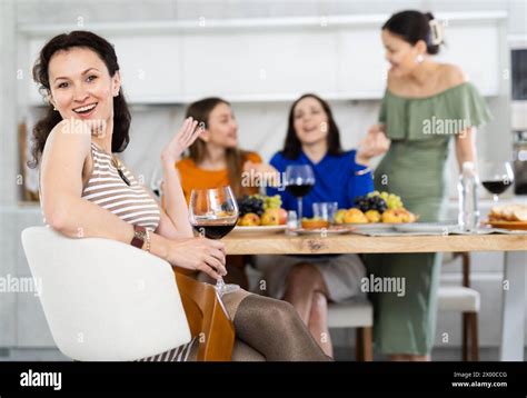 Happy Caucasian Girl Sitting In Front Of Friends Group With Her Back