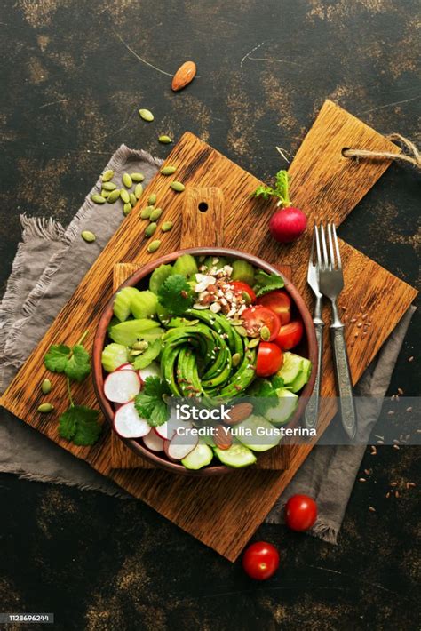 건강 한 채식주의 샐러드와 신선한 야채아보카도 무 토마토 오이 셀러리 절단 보드에 씨 최고의 볼 수 있습니다 갈색에 대한 스톡