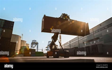 Modern Container Handler Carrying A Large Red Steel Shipping Cargo