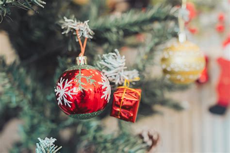 밝은 색상의 장식품이 나무에 매달려 있으며 눈송이 디자인의 빨간 공과 반짝이는 금색 장식이 작은 빨간 선물 상자와 함께 있습니다 0명에 대한 스톡 사진 및 기타 이미지